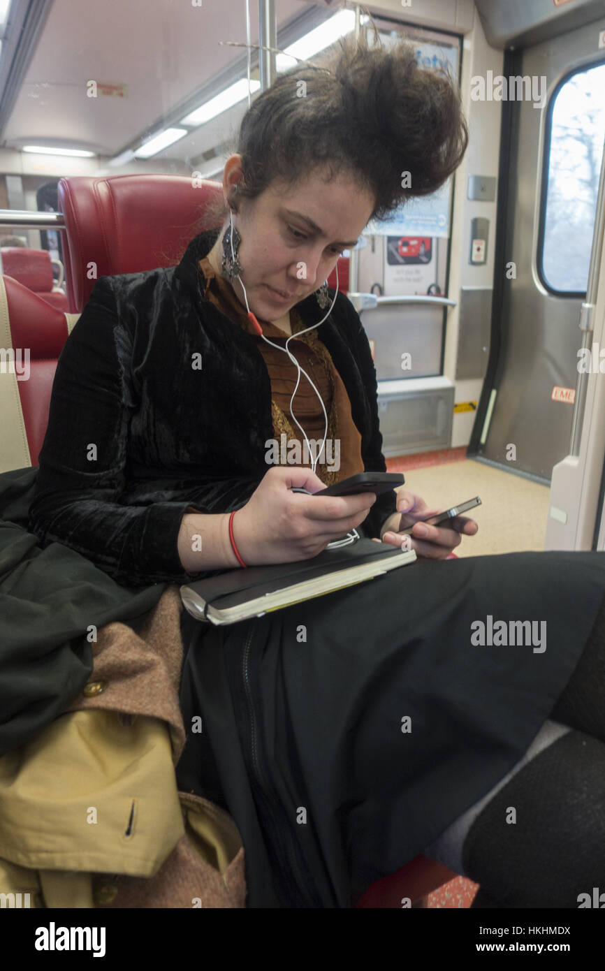 Young woman on her phone riding a Metro North commuter train out from ...