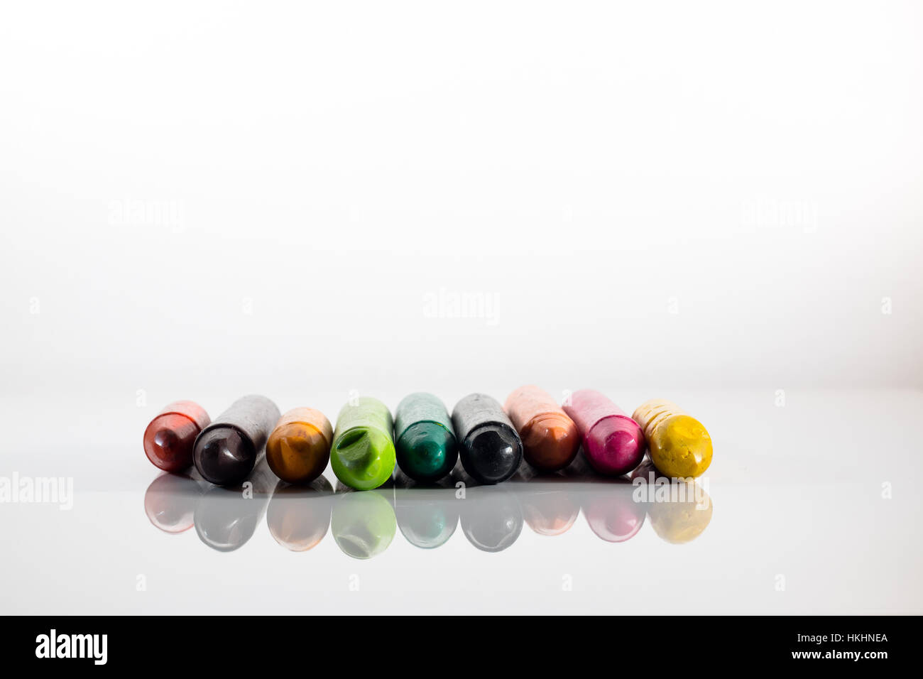 Isolated crayons of different colors against a white background casting ...