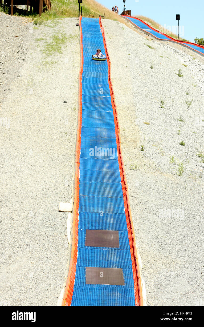 Children sliding downhill on long tubing run Stock Photo - Alamy