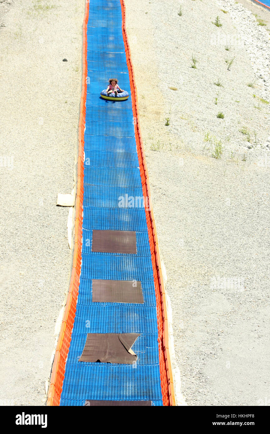 Children sliding downhill on long tubing run Stock Photo - Alamy