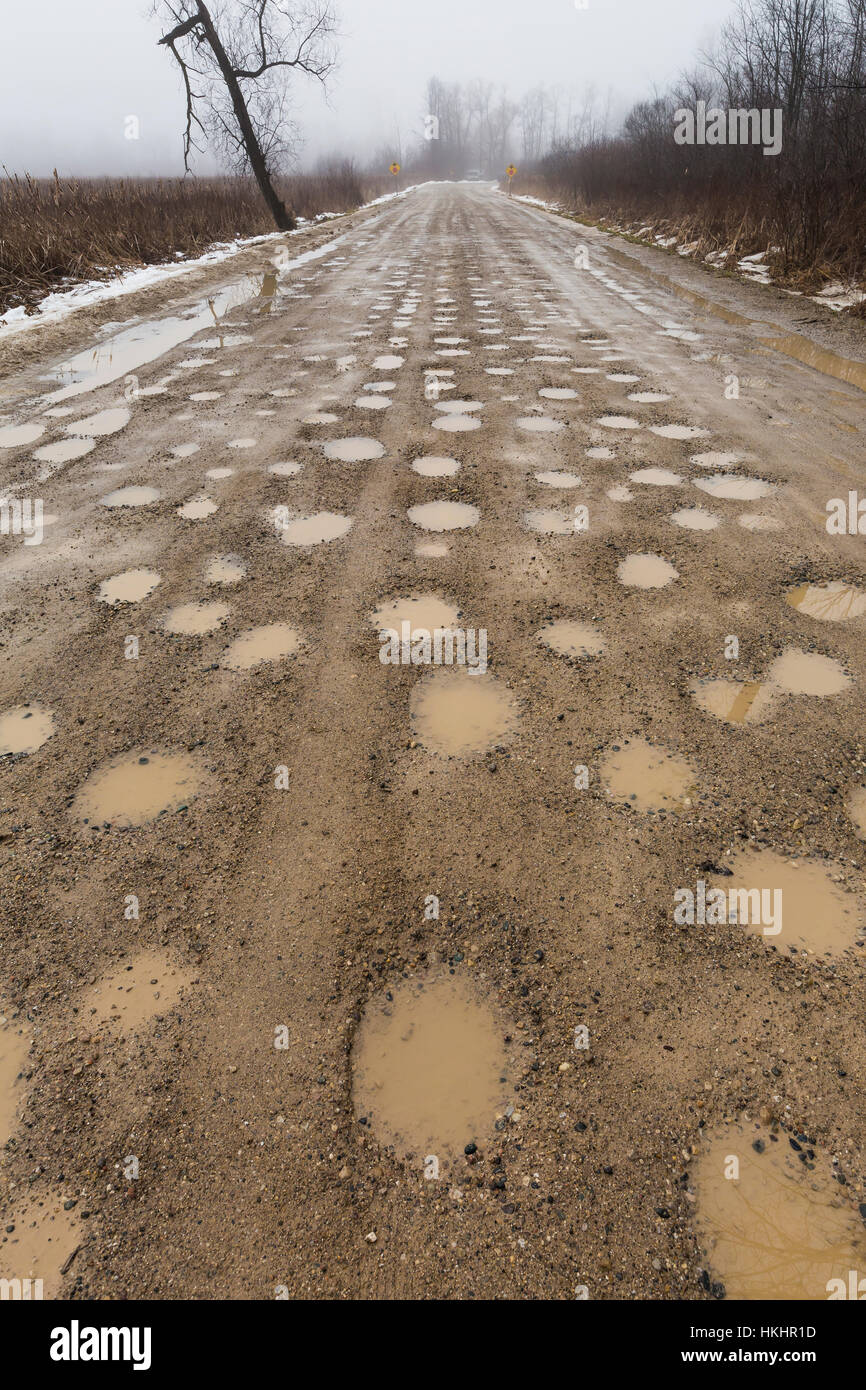 Sand road with potholes during a January thaw in central Michigan, USA ...