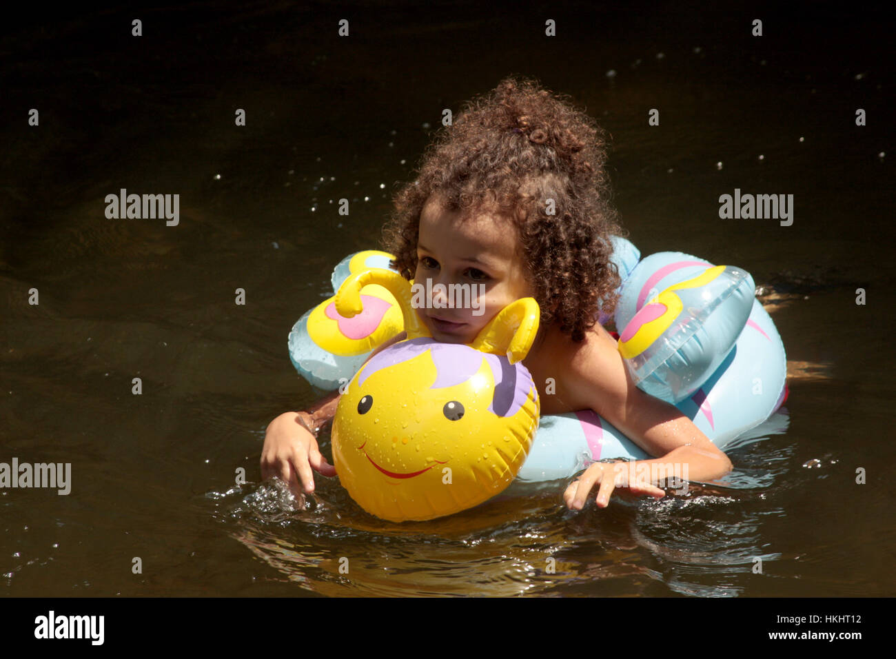 Little cute girl swimming with floater Stock Photo - Alamy