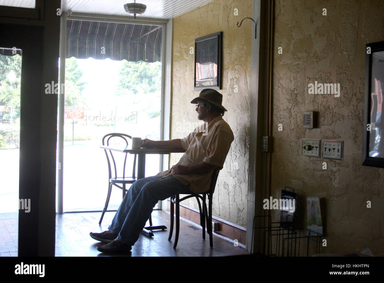 Man sitting alone at table in coffee shop Stock Photo - Alamy