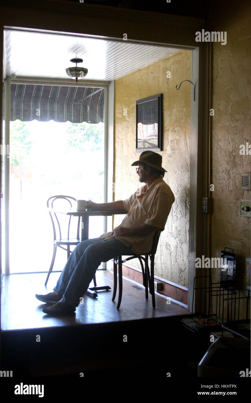 Man sitting alone at table in coffee shop Stock Photo - Alamy