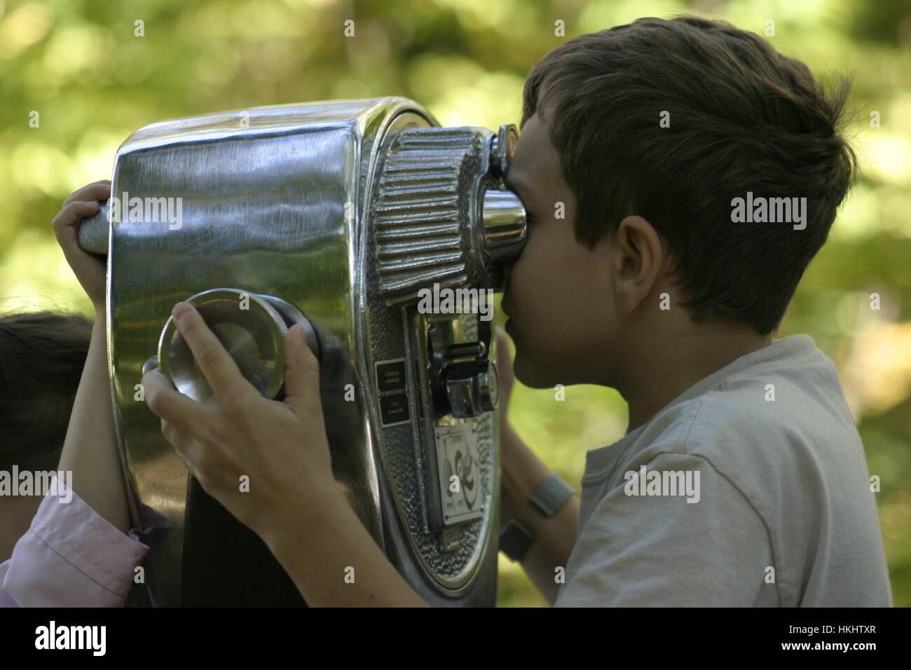 Young boy observing the animals through a coin viewer at Zoo Stock ...
