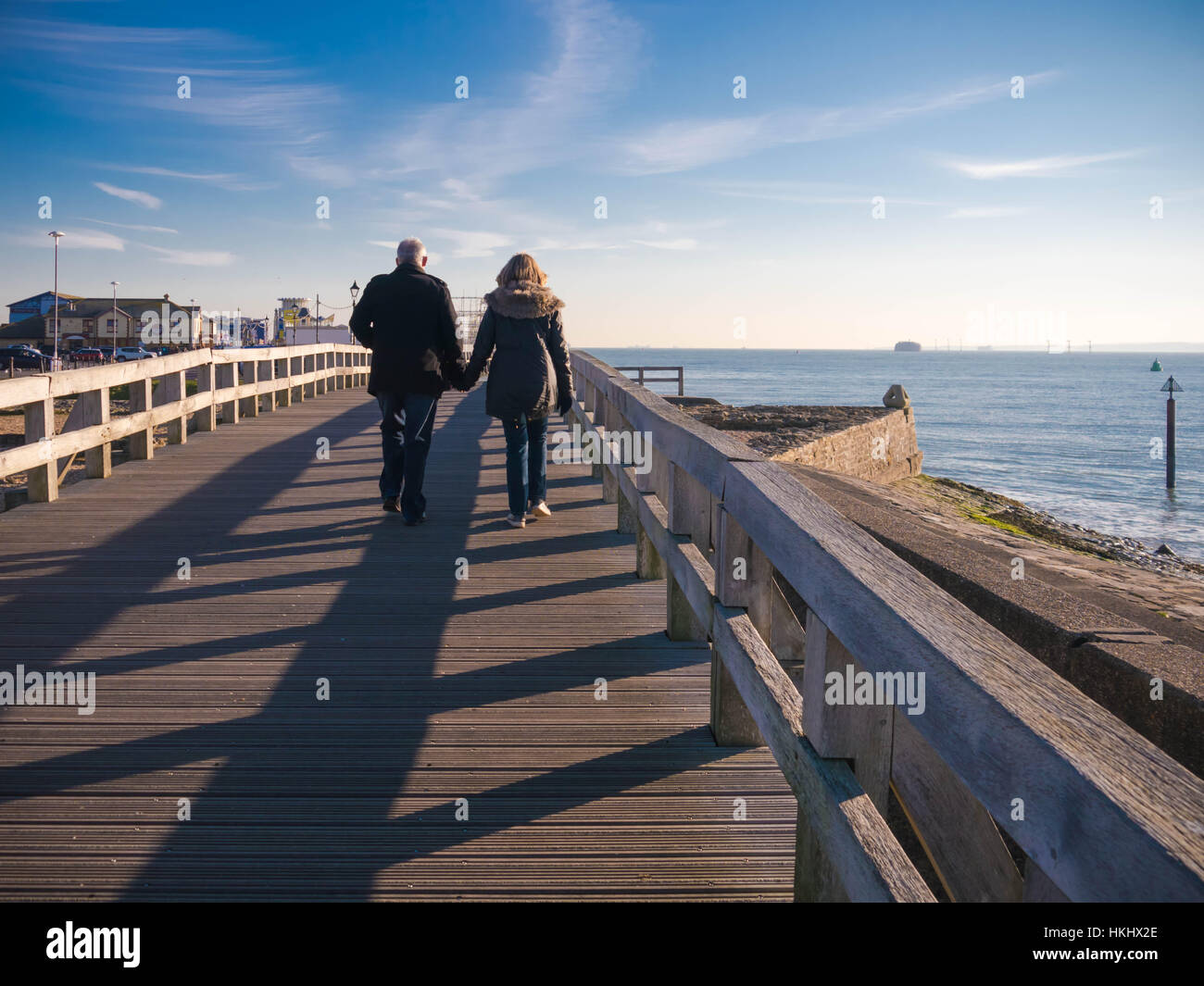 A couple walk hand in hand along Southsea seafront in Portsmouth ...