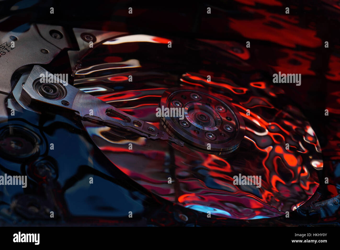 Opened Computer hard disk drive in studio with dark red and blue ...