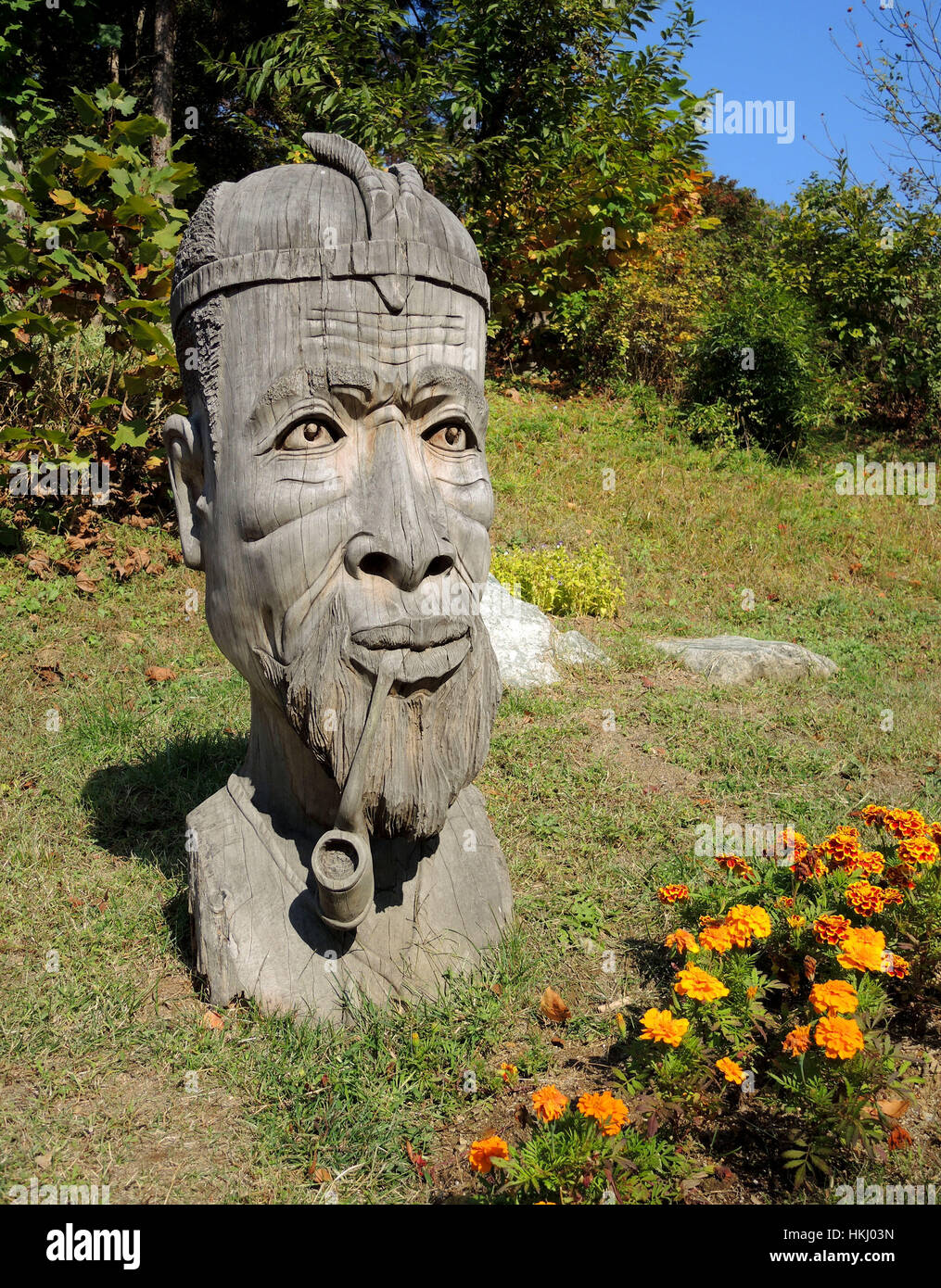 wooden statue of man smoking a pipe Stock Photo - Alamy