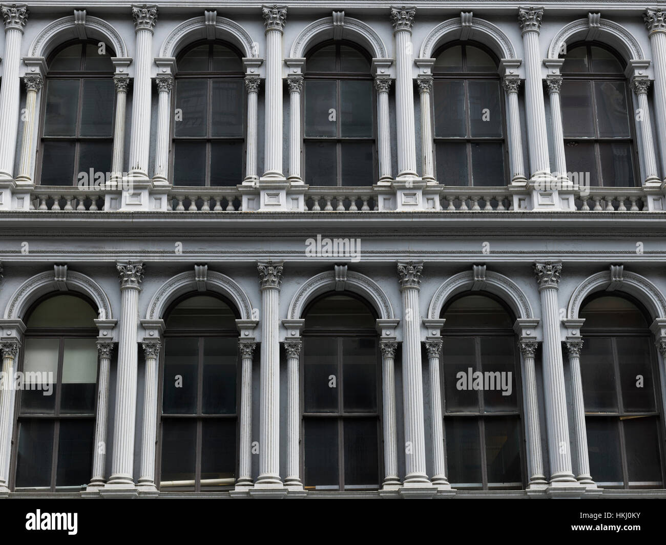 A building's facade with white pillars and arched windows; New York ...