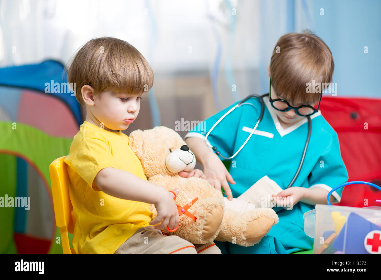 children playing doctor and curing plush toy at home Stock Photo - Alamy