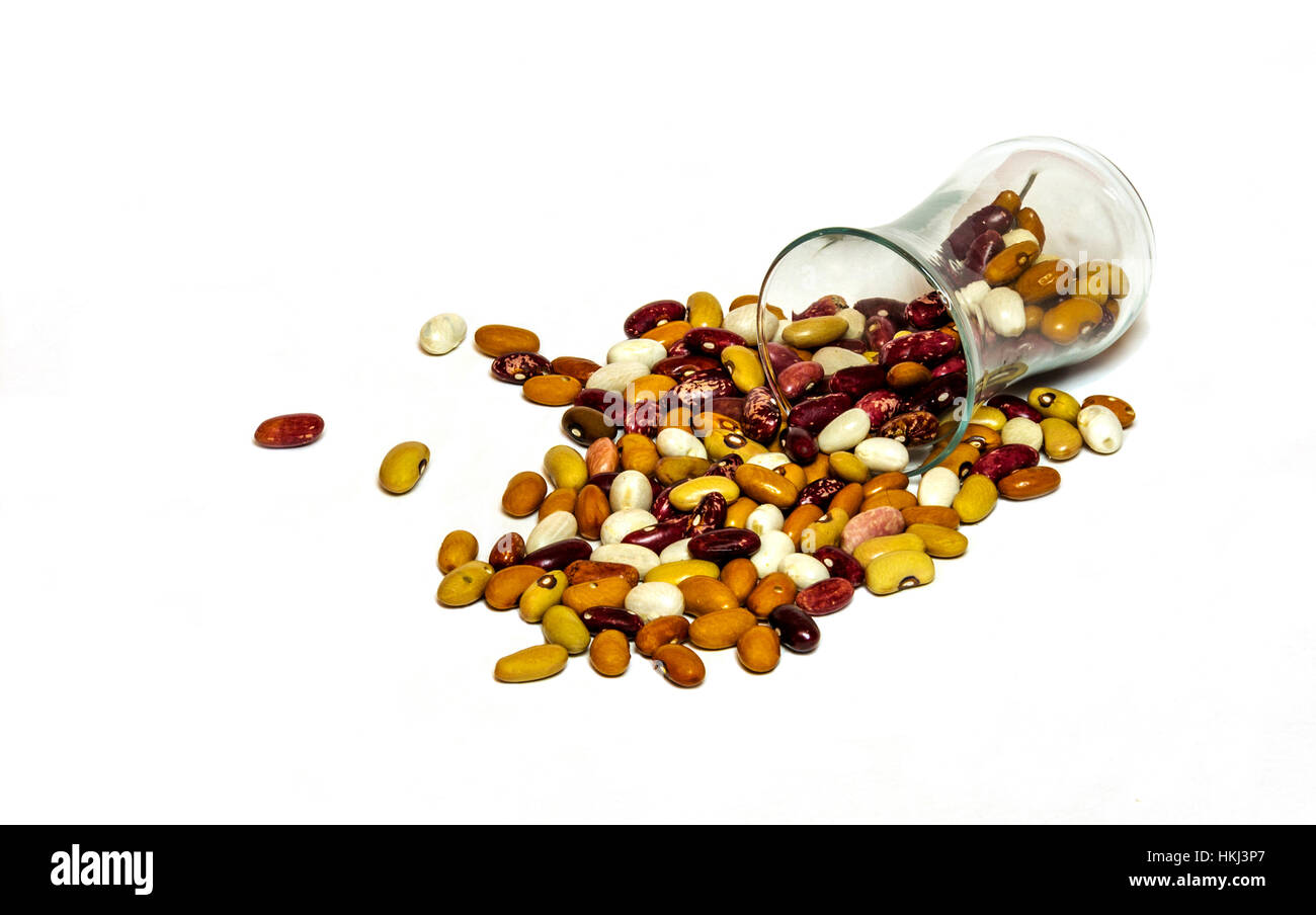 On the white surface are scattered from the glass beaker bean beans ...