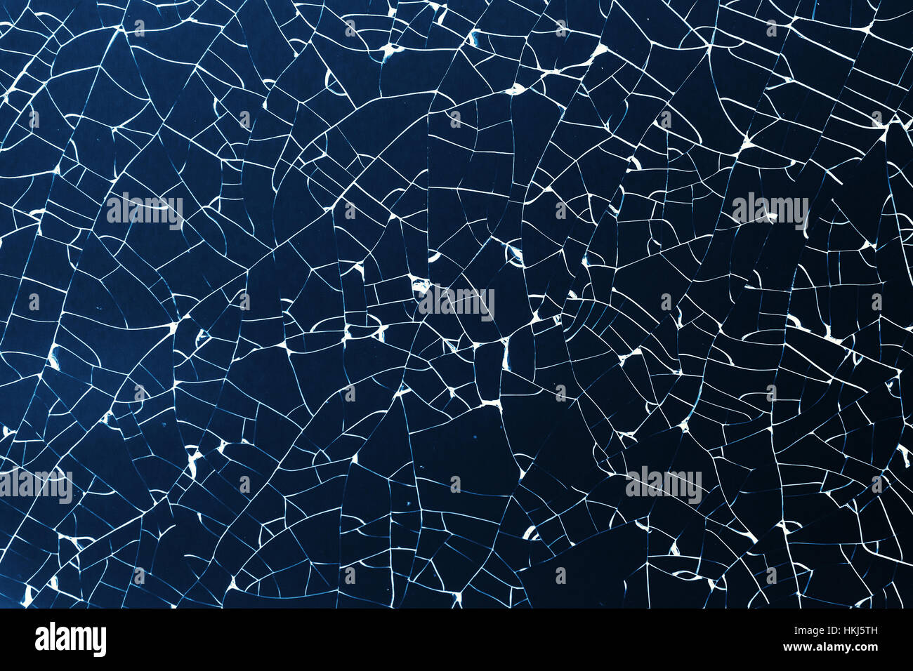 Broken strained glass with cracks and fragments over dark blue ...