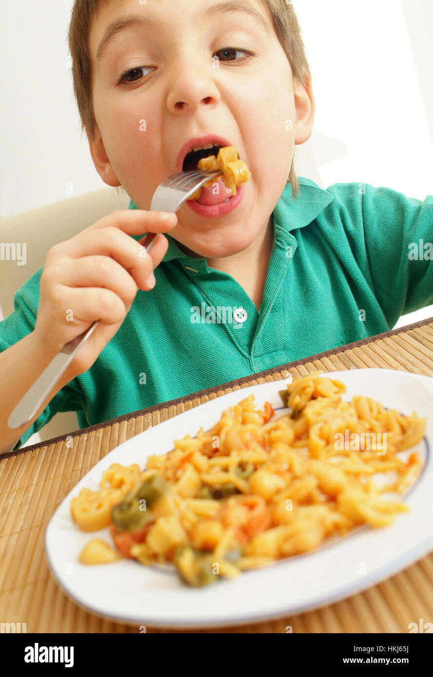 Boy eats pasta dish Stock Photo - Alamy
