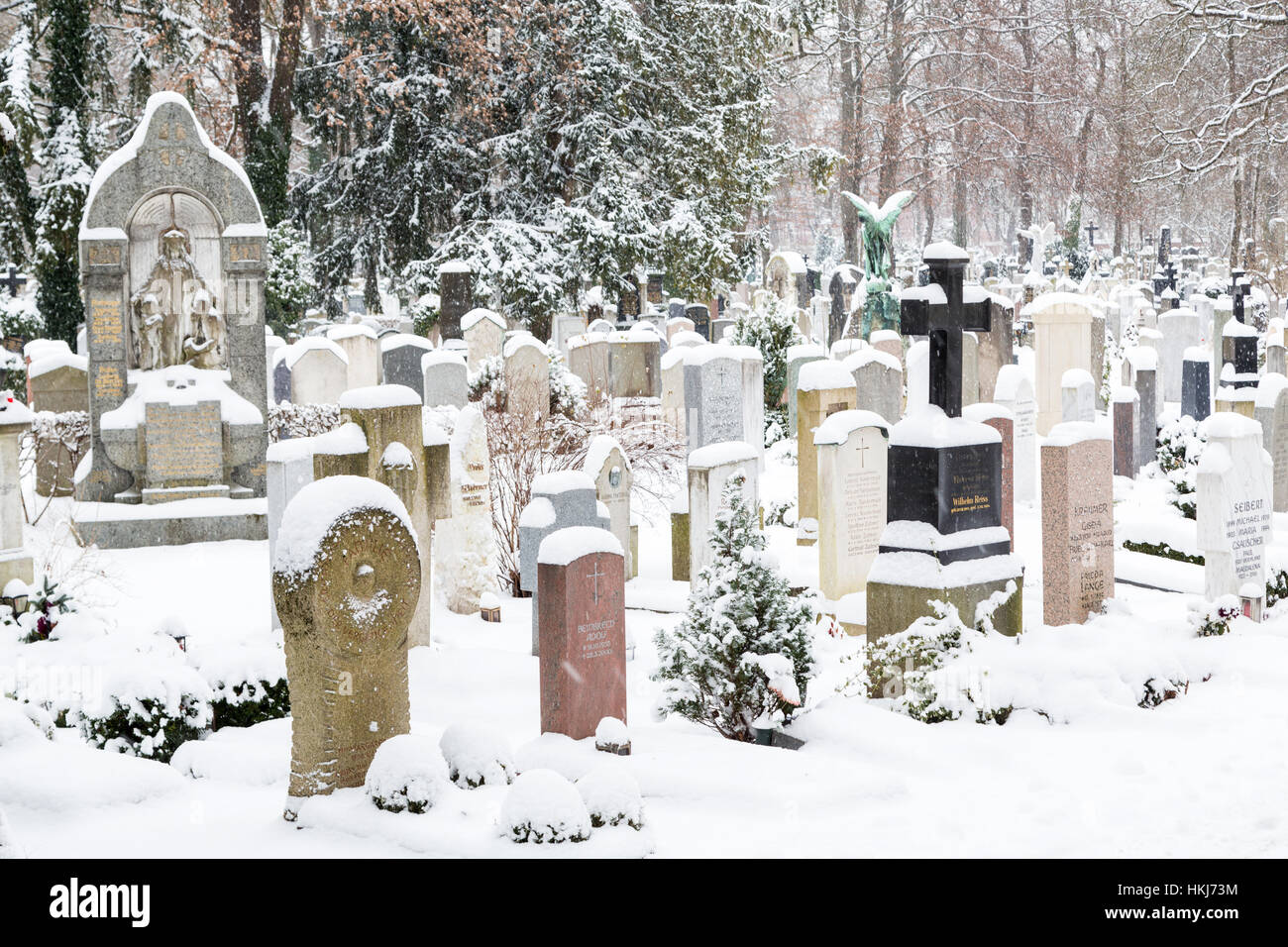 Grave stones at snowy cemetery in winter, Ostfriedhof, Munich, Bavaria ...