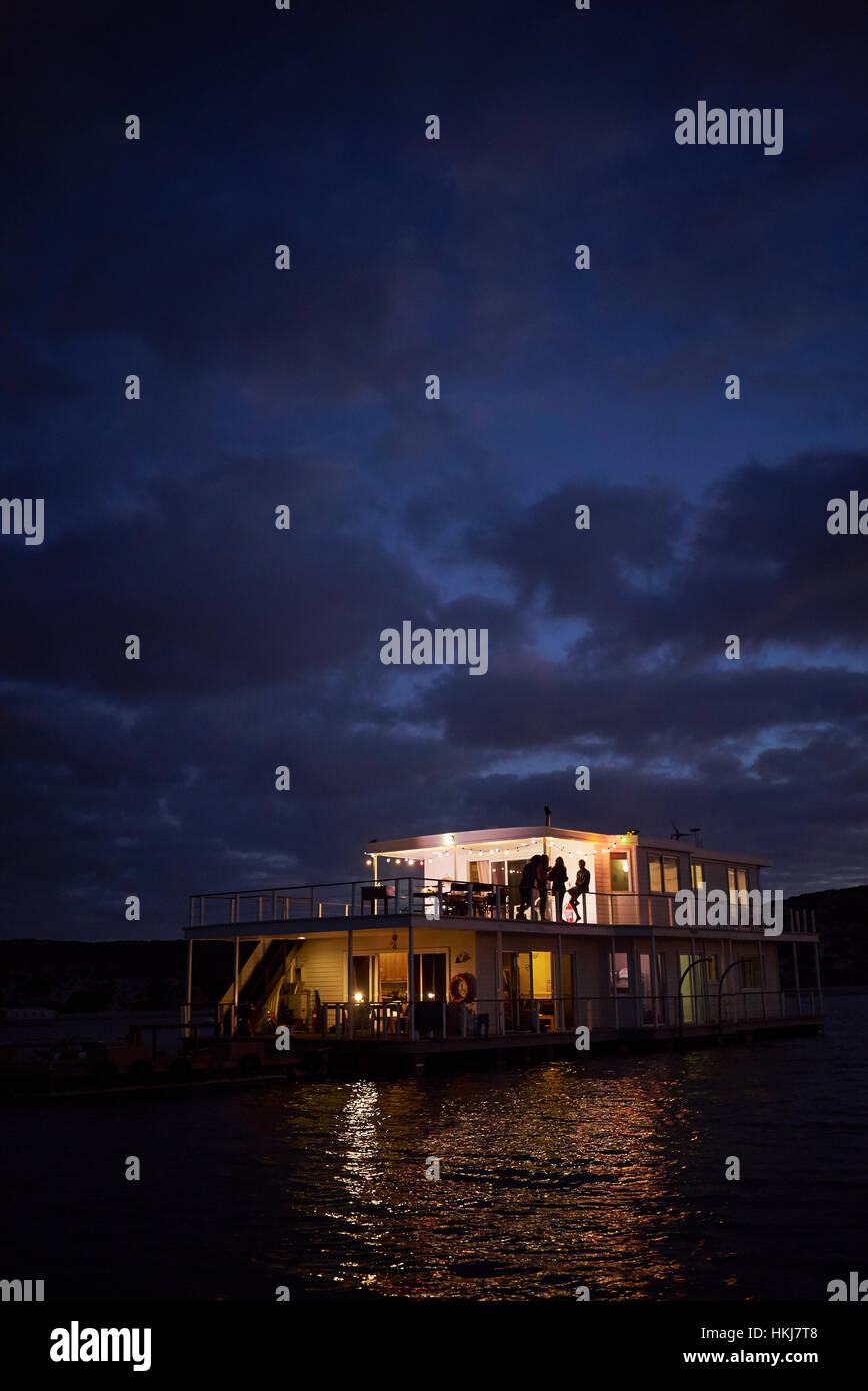Summer houseboat illuminated on night ocean Stock Photo - Alamy
