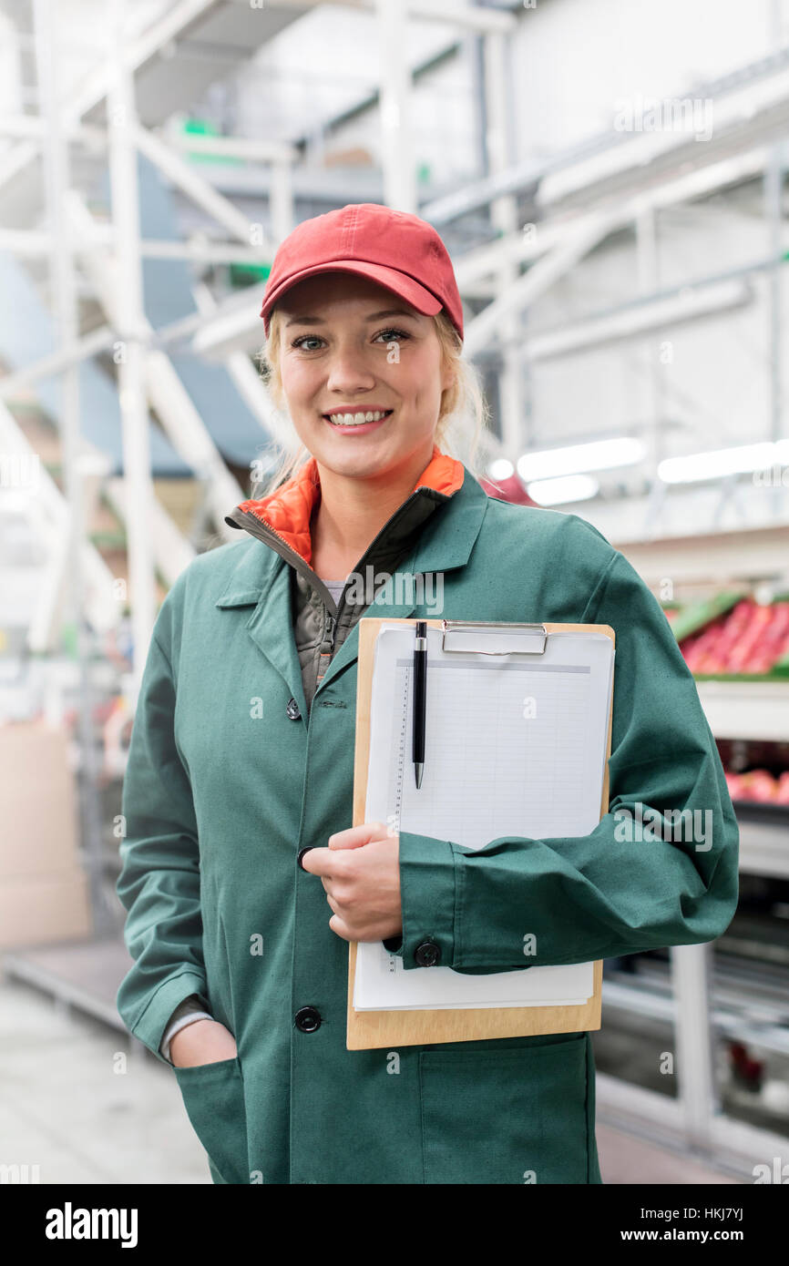 Portrait smiling worker with clipboard in food processing plant Stock ...