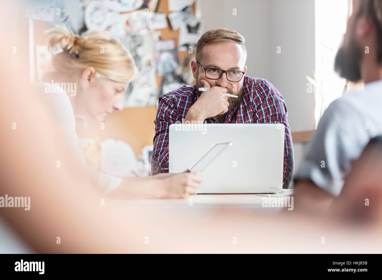 Pensive design professional thinking at laptop Stock Photo - Alamy