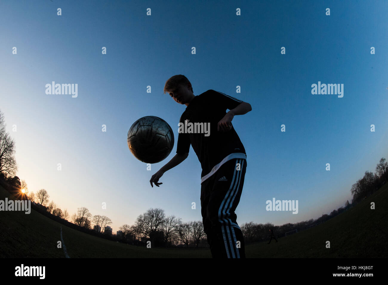 a young boy playing football and practicing his football skills and ...