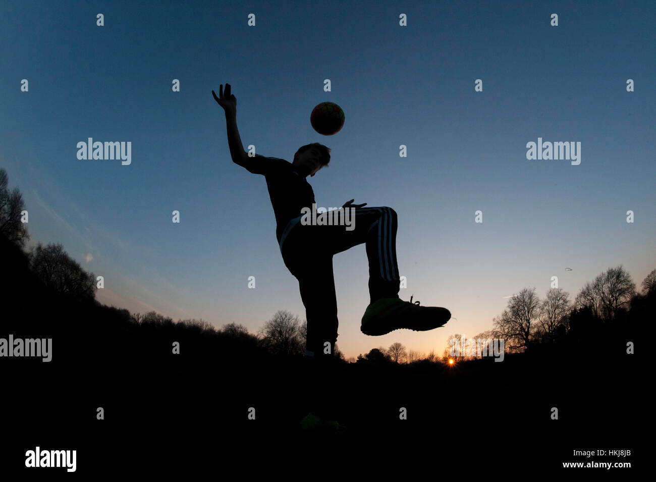 a young boy playing football and practicing his football skills and ...