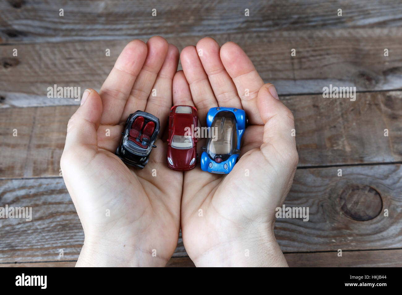 Three miniature cars on the palms of a woman's hands Stock Photo - Alamy