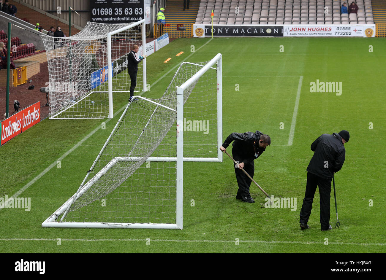 Ground staff rake the pitch in one of the 18 yard boxes before the ...
