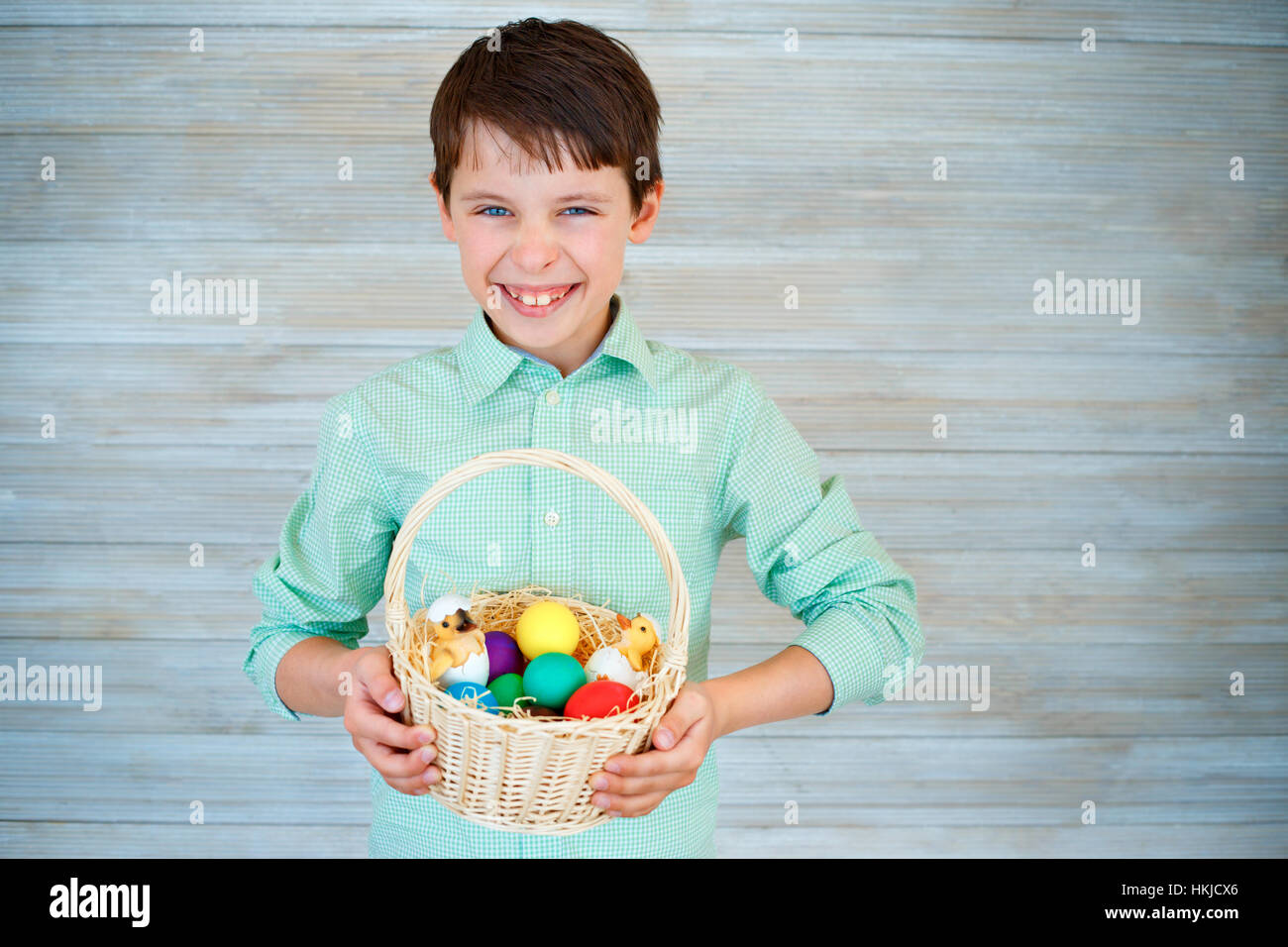 Cute little boy holding basket with colorful eggs after easter egg hunt ...