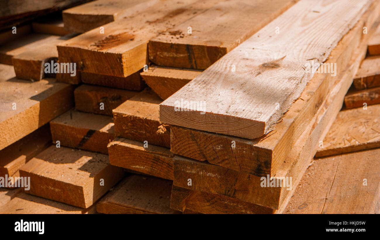 Stack of new wooden studs at a lumber yard warm color tone selective ...