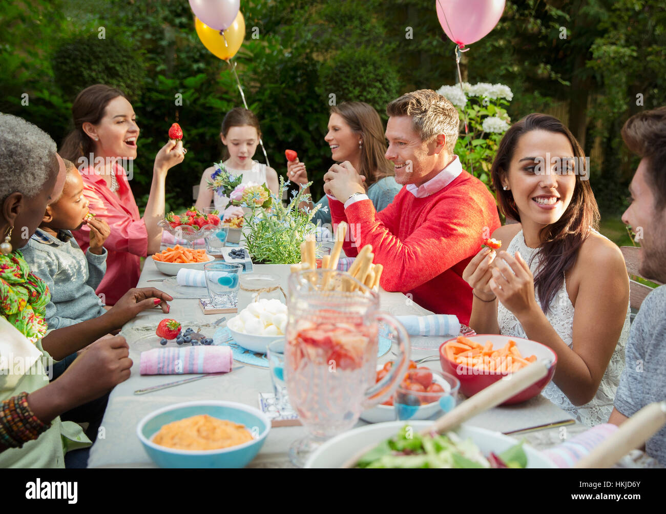 Family and friends enjoying birthday garden party at patio table Stock ...