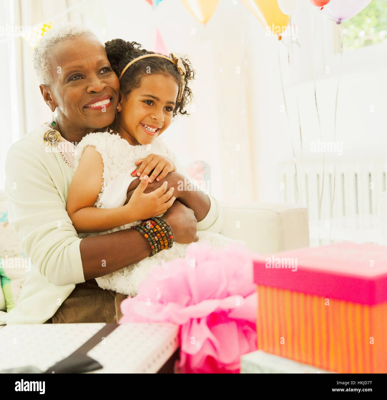 Affectionate grandmother and granddaughter hugging at birthday party ...