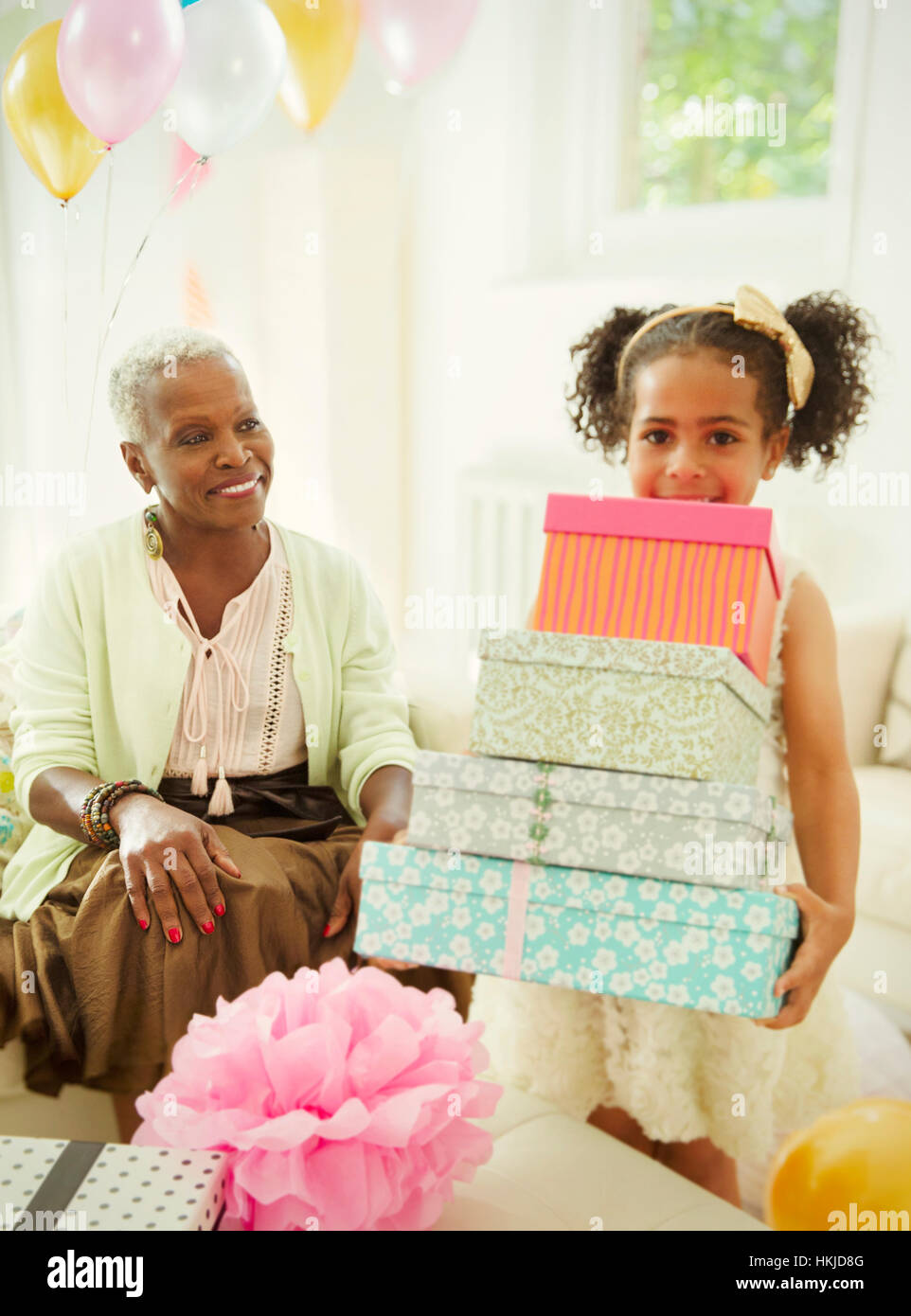 Portrait girl carrying stack of birthday gifts Stock Photo - Alamy