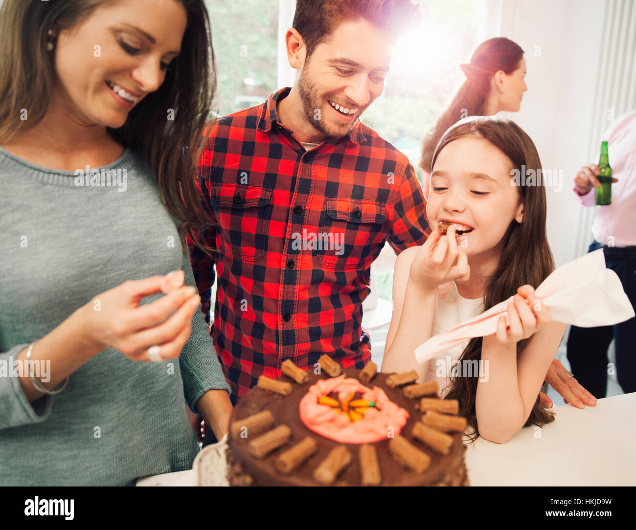 Family icing and decorating chocolate cake Stock Photo - Alamy