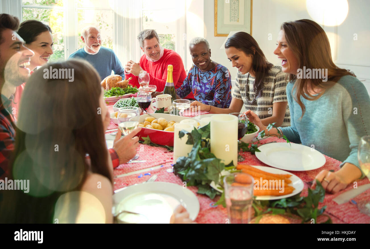 Laughing multi-ethnic family enjoying Christmas dinner at table Stock ...