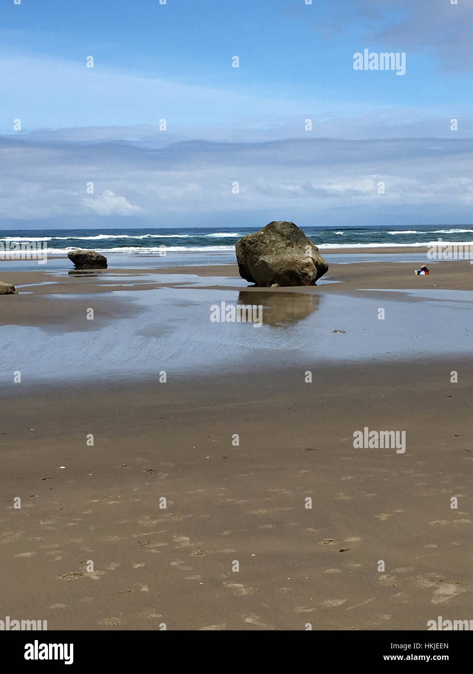 Large rocks on sandy beach with blue skies and clouds Stock Photo - Alamy