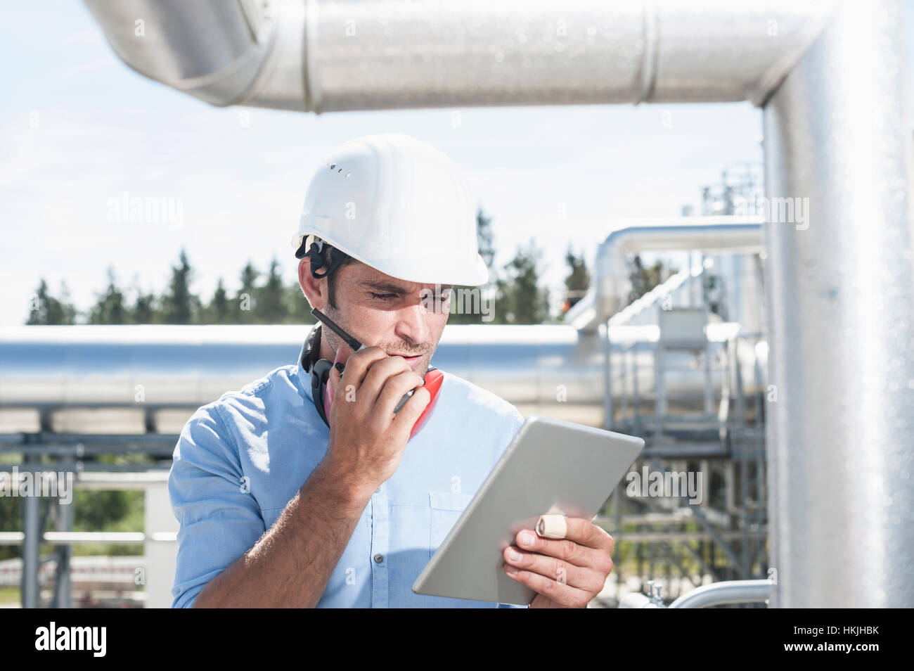 Male engineer talking with walkie-talkie at geothermal power station ...