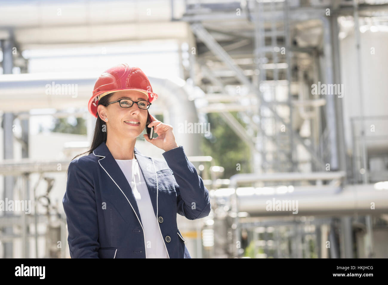 Female engineer talking on mobile phone at geothermal power station ...