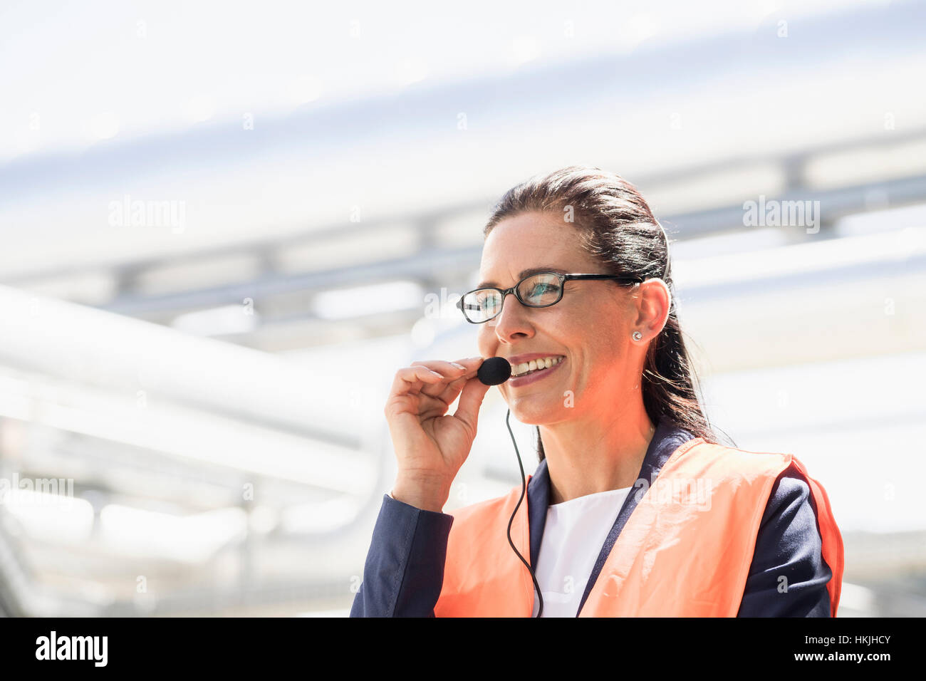 Female engineer wearing headset and smiling at geothermal power station ...