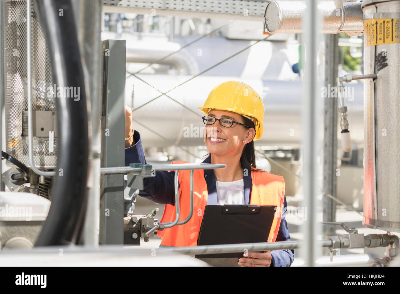 Female engineer smiling with document at geothermal power station ...