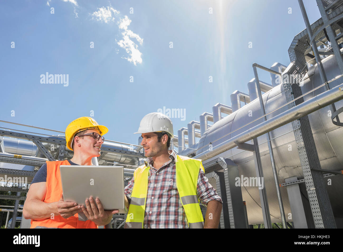 Engineer with his colleague in meeting with laptop at geothermal power ...