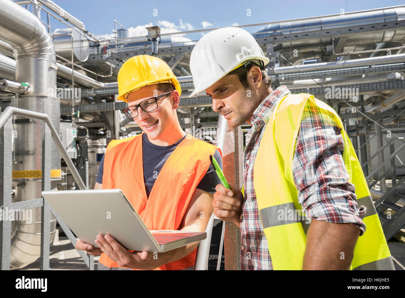 Engineer with his colleague in meeting with laptop at geothermal power ...