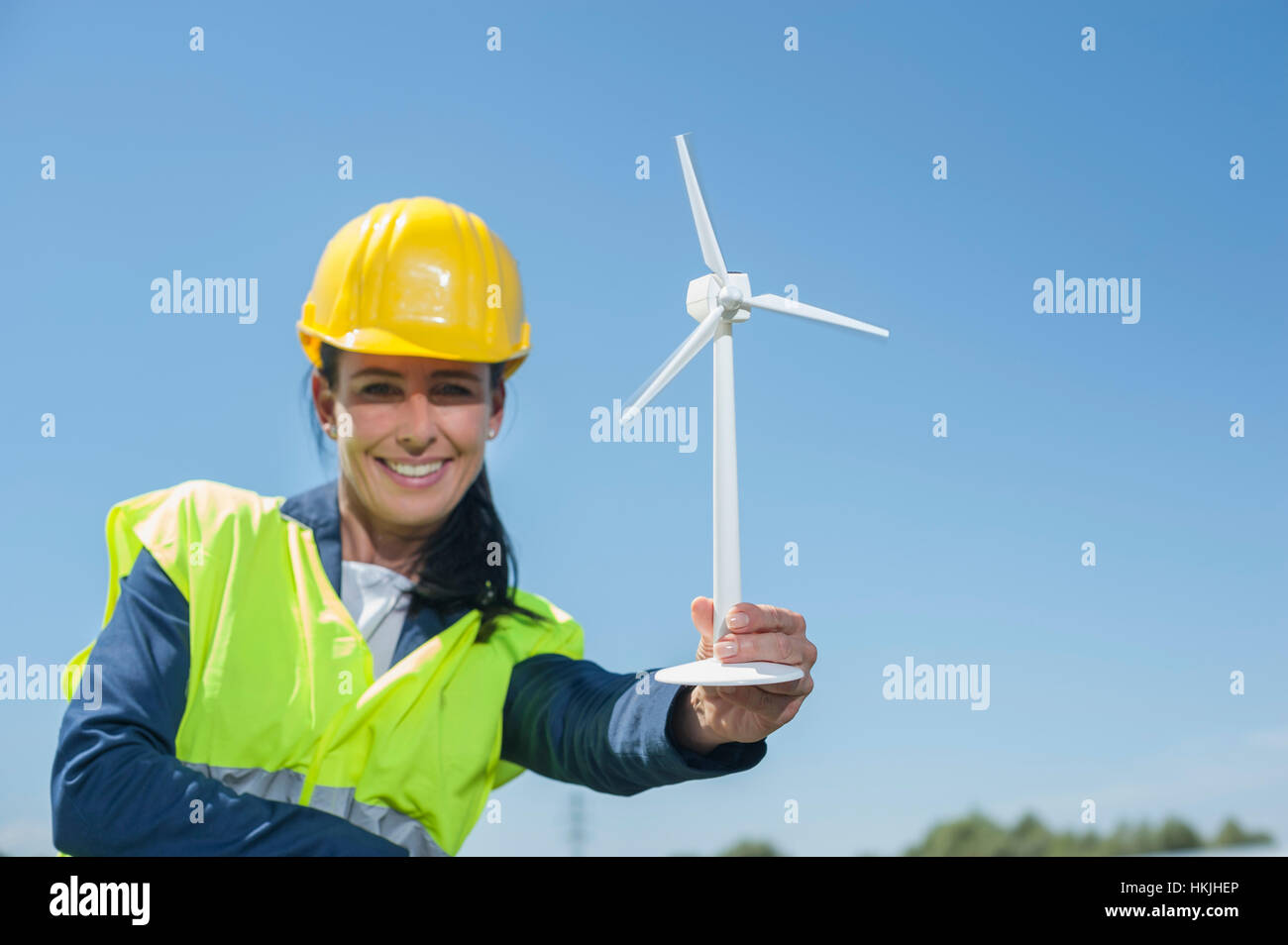 Female engineer showing wind turbine at geothermal power station ...