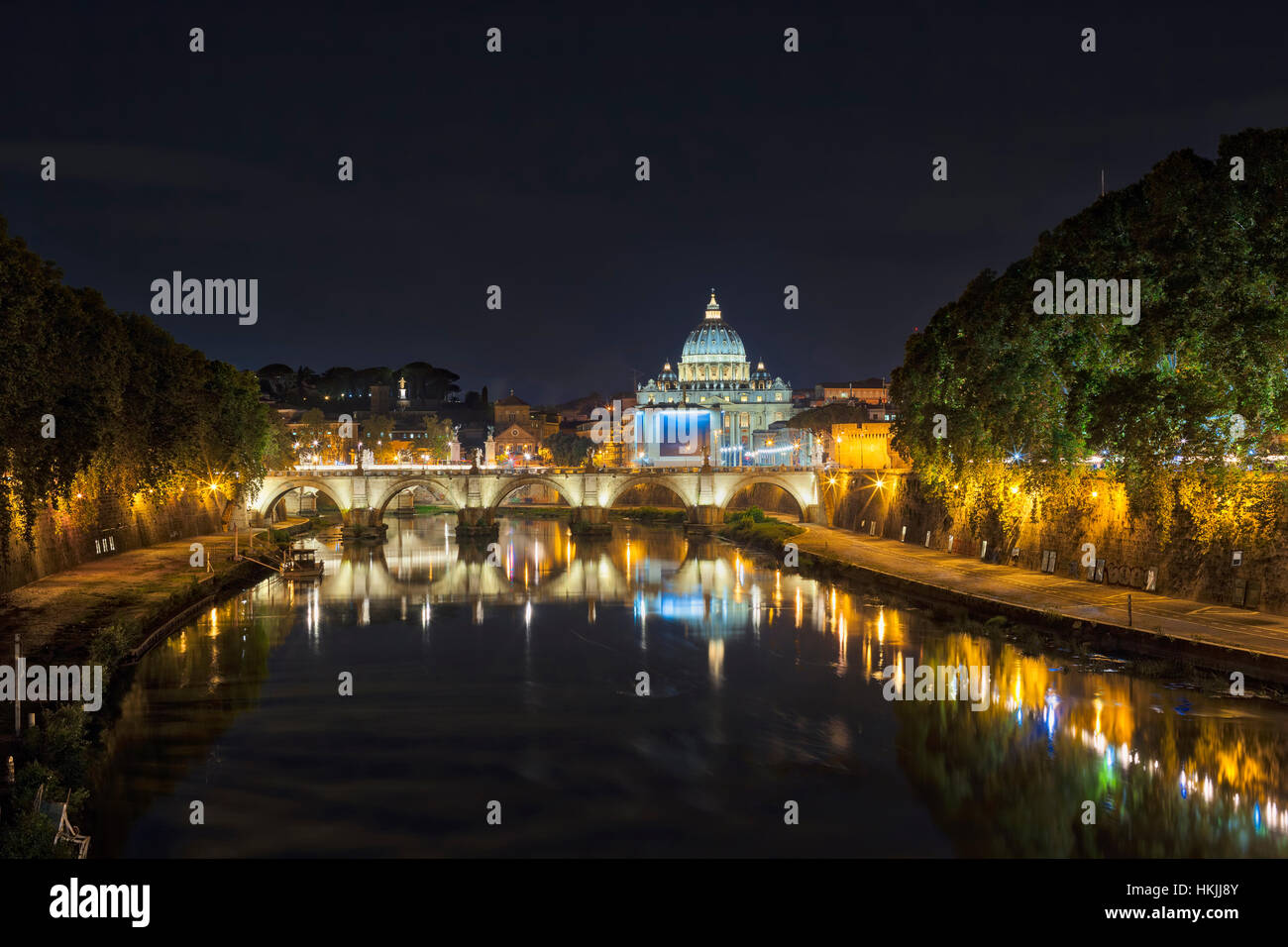 Illuminated St. Peter's Basilica by bridge over river at night, Rome ...