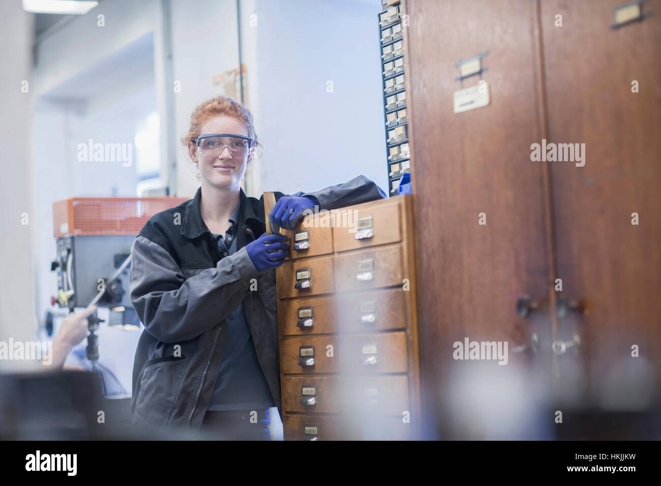 Portrait of a young female engineer standing in an industrial plant ...