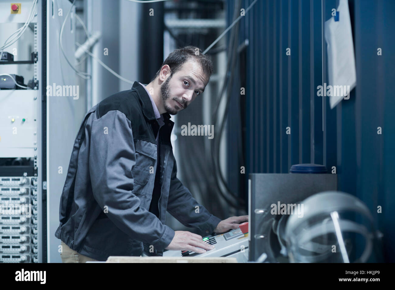 Young male engineer updating control panel in control room, Freiburg Im ...