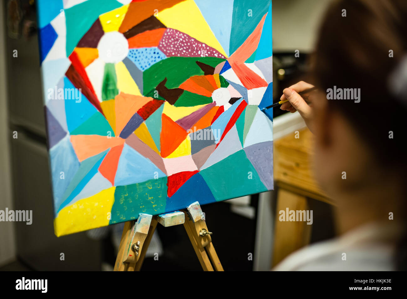artist painting with acrylic colors and mixing tones on the pallet ...