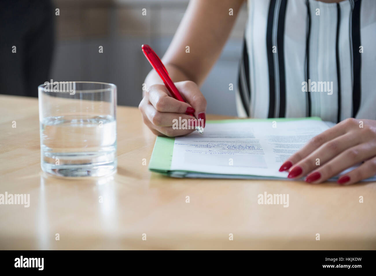 Woman signing paperwork hi-res stock photography and images - Alamy