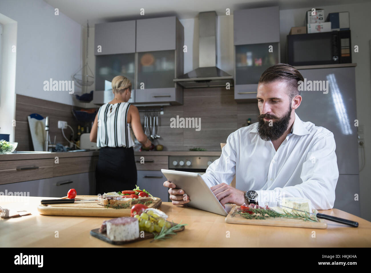 Young man looking recipe on digital tablet for meal in the kitchen ...