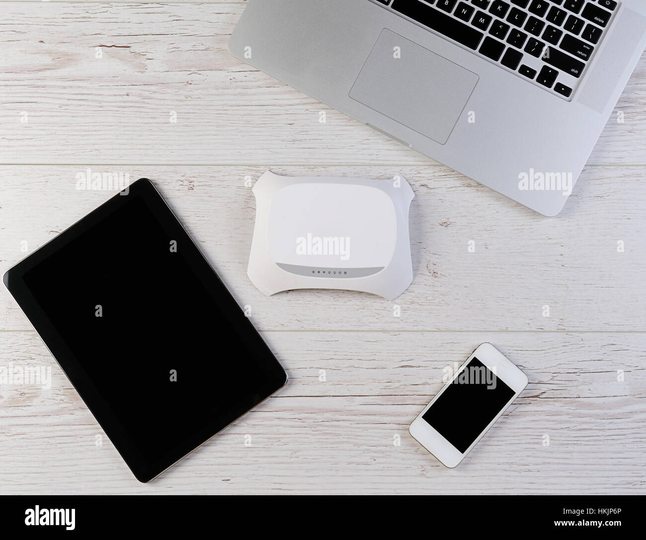 wifi router modem between laptop tablet and smartphone on wood Stock ...