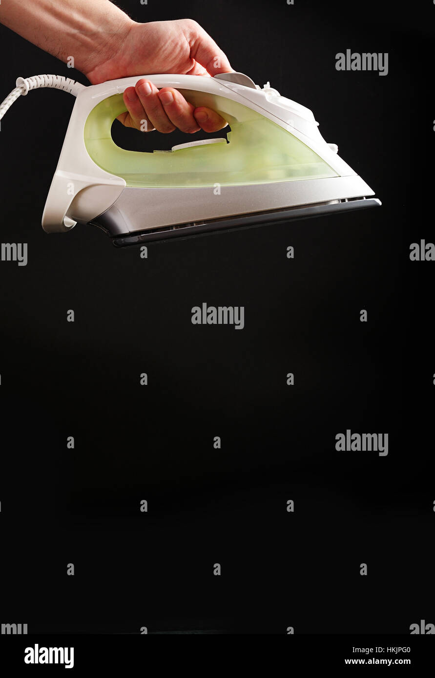 hand hold iron isolated on black background Stock Photo - Alamy