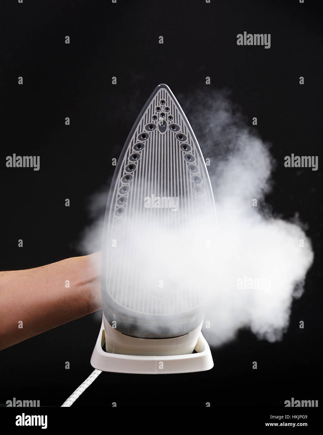hand hold iron with steam going on black Stock Photo - Alamy