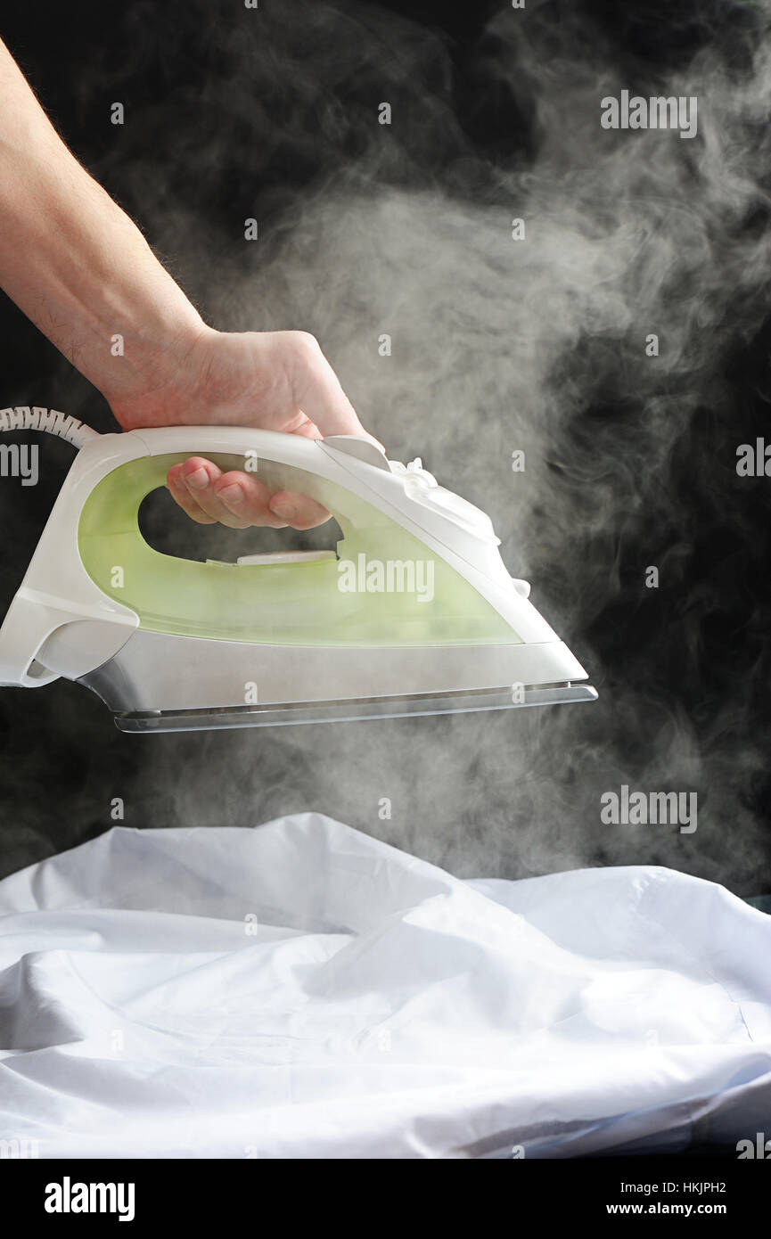 ironing with steam white cloth on black background Stock Photo - Alamy